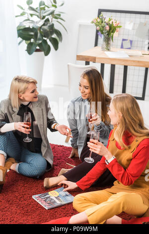 successful multicultural magazine editors celebrating with champagne in ...