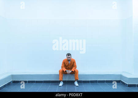 prisoner sitting on bench in prison cell Stock Photo - Alamy