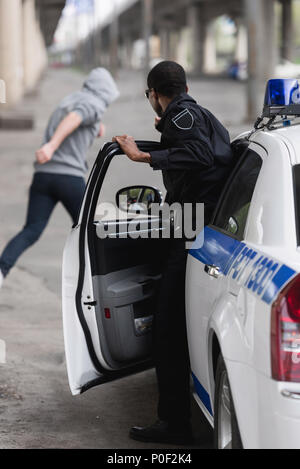 Police officer getting out of his car with his citation book in his ...