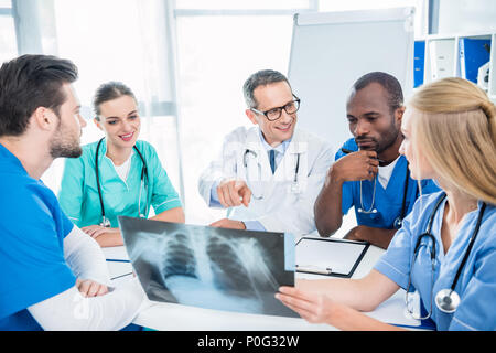 Concentrated multiethnic team of doctors men and women in workwear ...