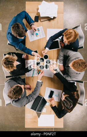 Top view of businesspeople sitting at table and using gadgets Stock ...