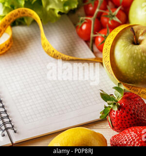 Blank notebook, pen, ripe fruits and vegetables on color background ...