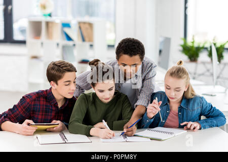 multiethnic group of teenagers doing homework together in class Stock Photo - Alamy