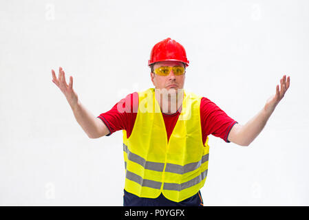 confused workman in safety helmet showing shrug gesture on blue Stock ...