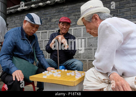 Seniors playing Janggi (Korean chess) on outdoor park bench - Busan ...
