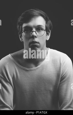 Upset male nerd in glasses looking down Stock Photo - Alamy