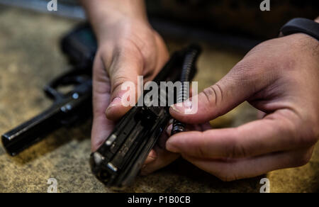 Small arms repair technician conducts a sight count of the weapons in ...