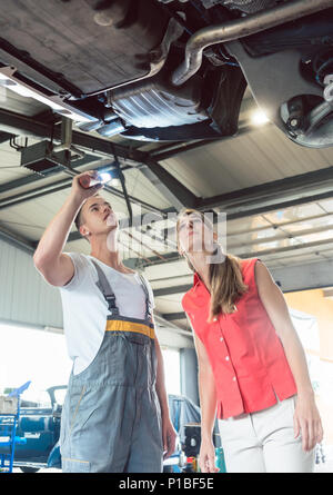 View into a modern auto repair shop with vehicles on service bays and a ...