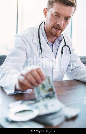 Bribery and corruption in medicine. Serious lady doctor in glasses and ...