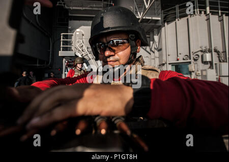 A weapons officer loads a 50-caliber machine gun for a live fire drill ...