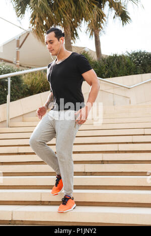 Photo of strong young sports man make stretching exercises at stadium ...