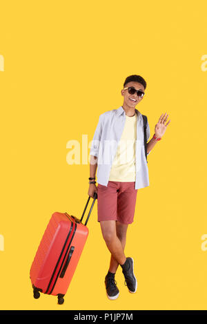 Joyful young male traveler waving Spanish flag during visit to ...