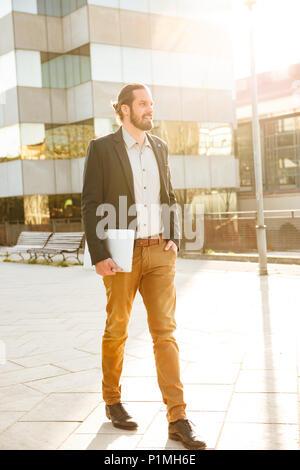 Man in formal wear holding champagne and looking at elegant girlfriend ...