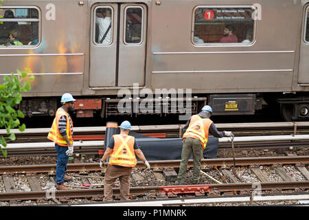 NYC Transit subway track workers place a protective rubber insulating ...