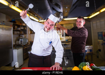 Two chefs in uniform fighting with kitchen utensils. Cooking. Culinary ...