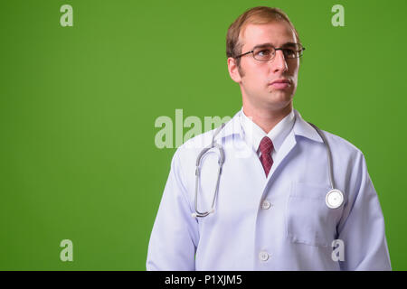 Young man doctor against green background Stock Photo - Alamy