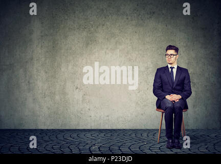Anxious scared man sitting and waiting for a job interview, he is ...