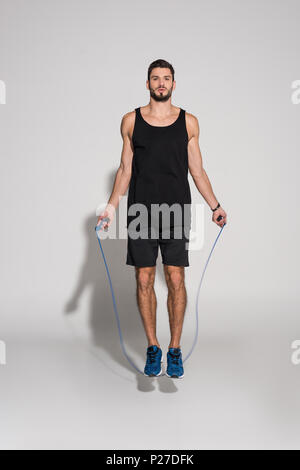 Young man with jumping rope on white background Stock Photo - Alamy