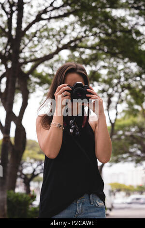 Woman clicking photo with digital camera Stock Photo - Alamy