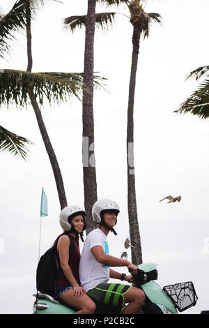 Cheerful young couple riding a scooter and having fun Stock Photo - Alamy