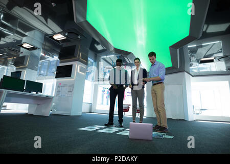 Male and female executives discussing over laptop at desk Stock Photo ...