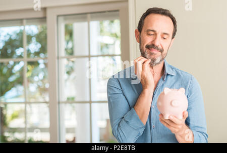 Handsome middle age man saving money of laundry detergent smiling and ...