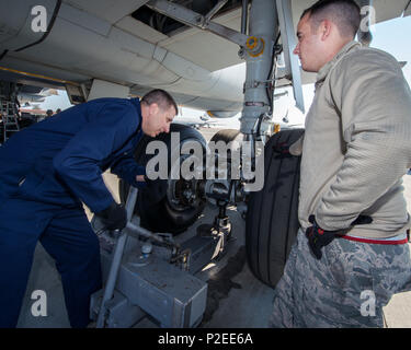A maintenance crew changes a tire on the nosewheel landing gear of an F ...