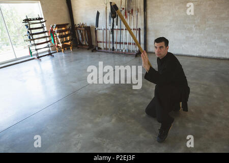 Kung fu fighter practicing with long pole Stock Photo - Alamy