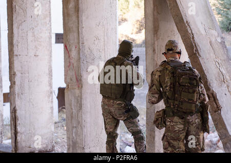 Soldier aiming his rifle with two soldiers talking behind him Stock ...