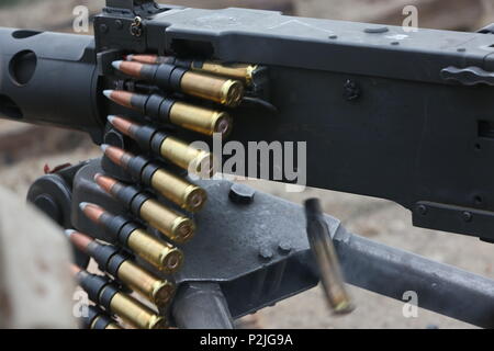A belt of .50-caliber rounds feed into an M2 machine gun during a ...