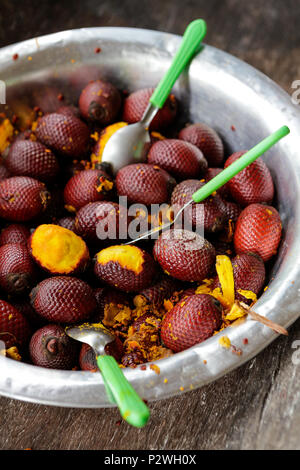Close up of fresh "buriti" fruit with spoons inside a metal bowl in ...