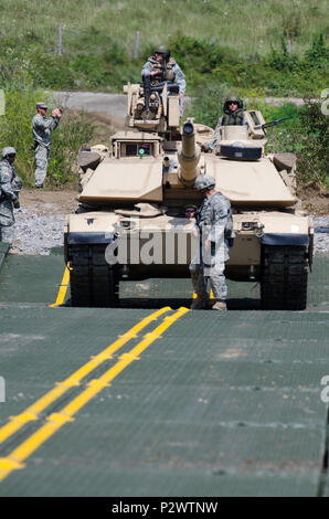 Soldiers drive an M-1 Abrams tank across a portable bridge during ...
