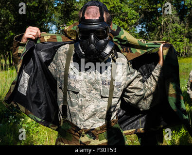 An Airman puts on a component of Mission Oriented Protective Posture ...