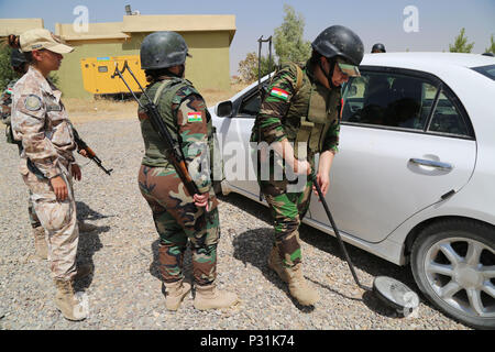 An Italian trainer observes Zeravani soldiers search personnel during a ...