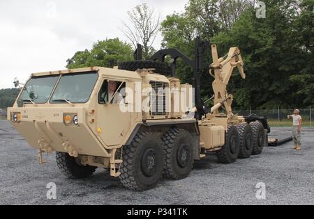 An M1075 Palletized Load System truck places a Field Packing Unit at ...