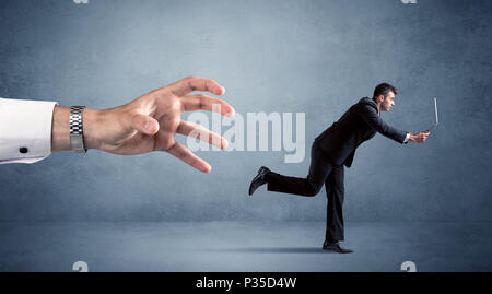 Young miniature businessman running from a big hand with light grey ...