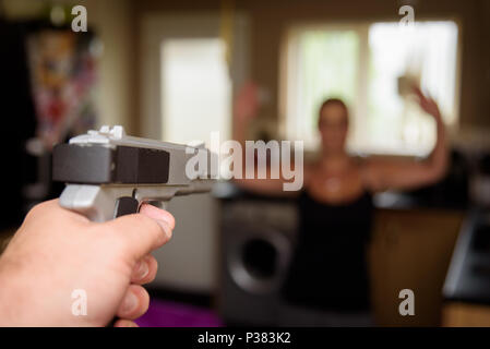 Woman held at gunpoint in her home by a burglar or intruder Stock Photo ...