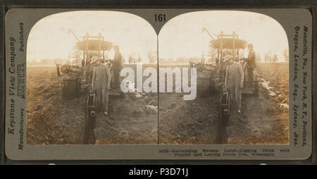 Reclaiming swamp land Digging ditch with tractor, and laying drain tile ...