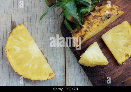 Pineapple and pineapple slices on an old wooden background Stock Photo ...