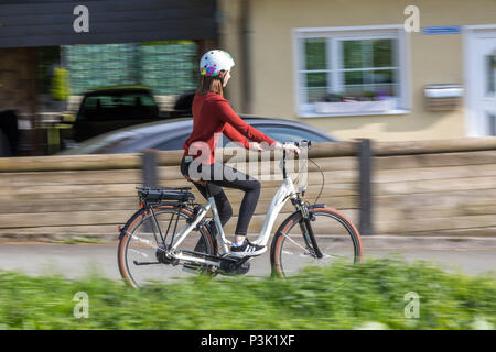 Young woman rides an e-bike, electric bike, electric motor assisted ...