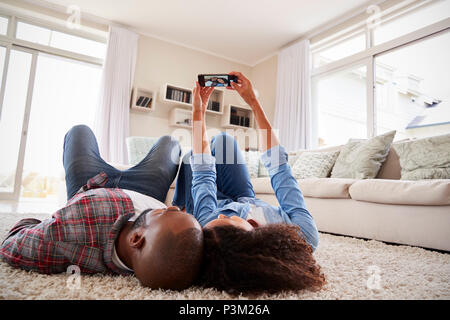 Woman posing lying on the floor on blue background Stock Photo - Alamy