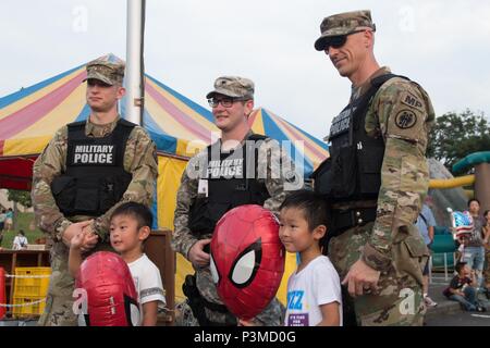 Two Japanese Army soldiers pose with a captured U.S. M3 Stuart tank ...