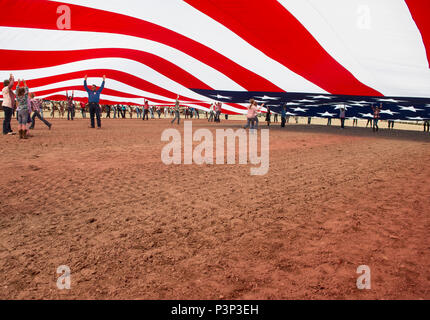 Volunteers unfurl an American flag on the outfield wall of Fenway Park ...