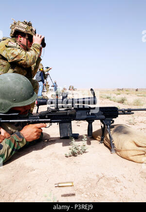 An Iraqi soldier fires an M14 sniper rifle as an Australian soldier ...