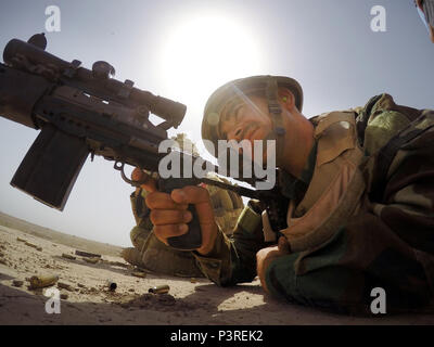 An Iraqi soldier fires an M14 sniper rifle as an Australian soldier ...