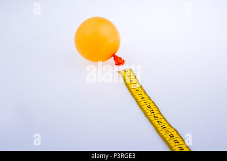 Yellow color measuring tape and a balloon on a white background Stock ...