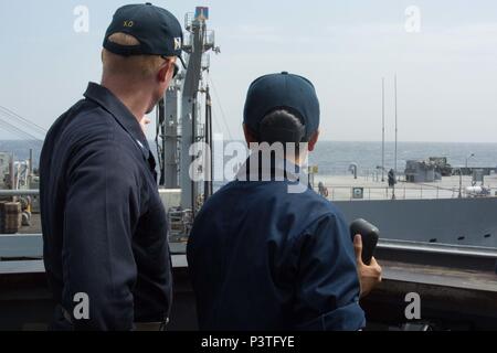 US Navy Cmdr. Timothy B. Spratto, right, renders a hand salute to ...