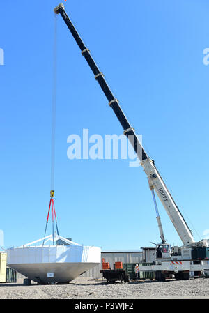 A construction crew works on a radome as part of a multi-step project ...