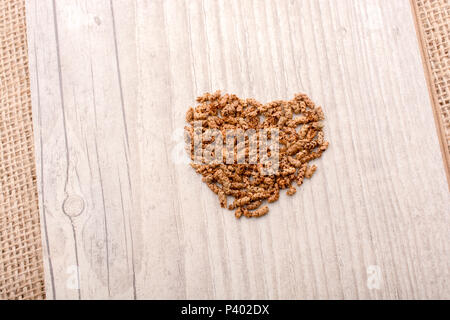 Brown leaves form heart shape on brown background Stock Photo - Alamy