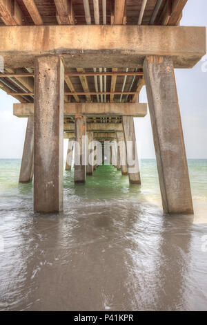Under the Naples Pier with a blue sky above in the summer in Naples ...